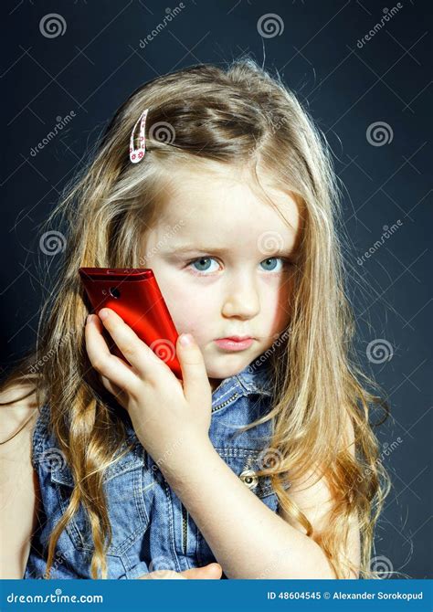 A Menina Bonito Fala Usando O Telefone Celular Novo Imagem De Stock