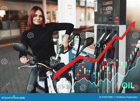 Glad Redhead Woman Biker Refilling Her Biker In Gas Station Stock Image