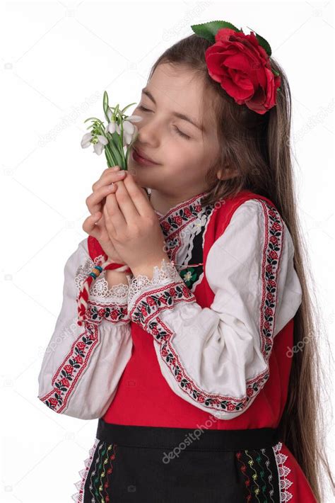 Chica búlgara en trajes folclóricos tradicionales con flores de gota de