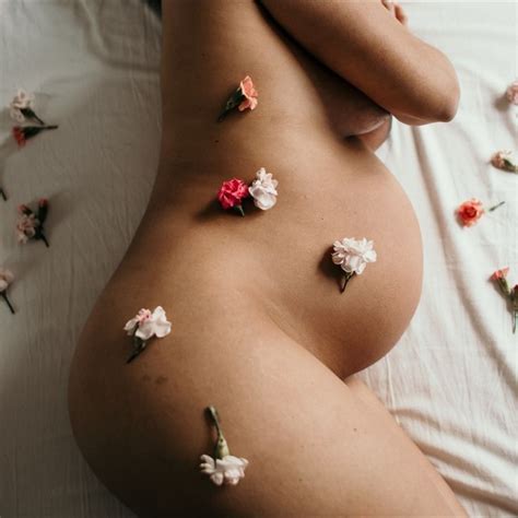 Naked Pregnant Woman Laying On A Bed Covered In Flowers Forget Me Not