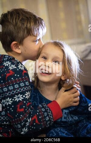 Deux frères et sœurs en pyjama avec livre soeur baiser frère drôle
