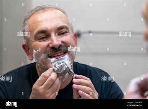 Middle Aged Handsome Man Shaving His Beard In Bathroom Stock Photo Alamy