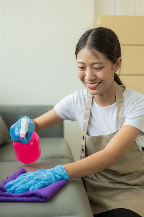 Beautiful Asian Housewife Doing Housework And Cleaning The House With An Apron Using A Vacuum