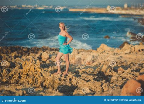 Seductive Blond Lady Woman With Naked Legs Shoulders And Arms Wearing Light Blue Open Dress