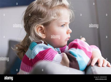 Niña mirando por la ventana fotografías e imágenes de alta resolución