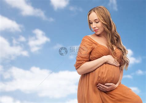 怀孕 母亲 人期望的快乐的孕妇触摸她的大肚子蓝天云彩的背景快乐的孕妇抚摸着她的腹部高清图片下载 正版图片300410302 摄图网