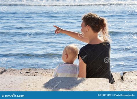 Maman Et Son Petit Fils Sont Assis Sur La Plage Et Regardent La Mer