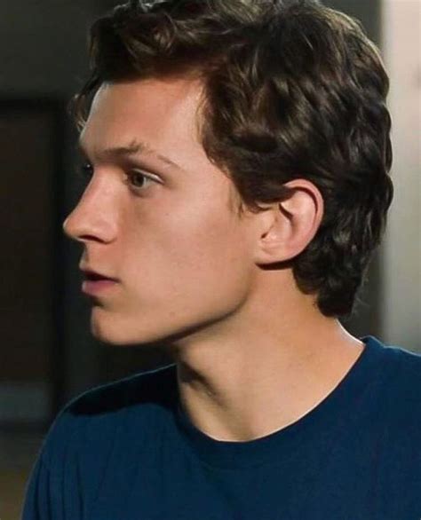 A Close Up Of A Person Wearing A Blue Shirt And Looking Off Into The