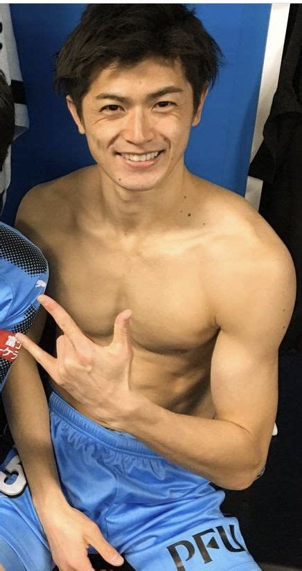 A Man Sitting On The Ground With His Shirt Off And Pointing At