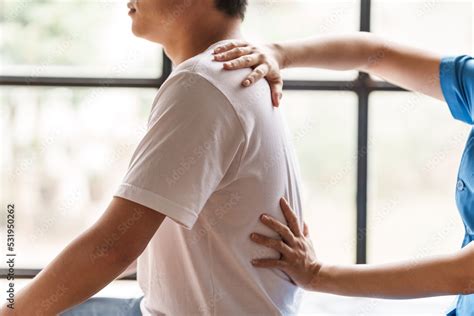 Physical Therapist Is Examining The Injured Arm Waist And Neck Muscles