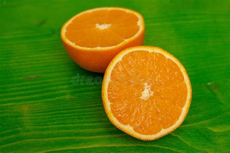 Dos Mitades De Una Naranja Madura En La Tierra Verde Foto De Archivo