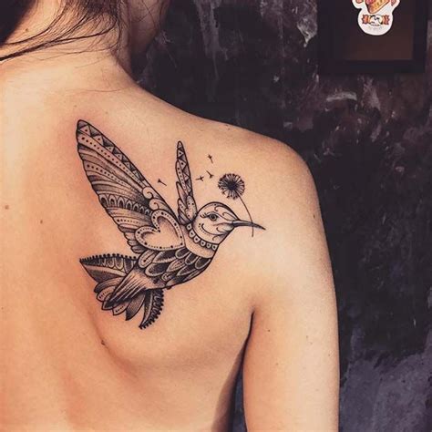 The Back Of A Woman S Shoulder With A Bird And Dandelion Tattoo