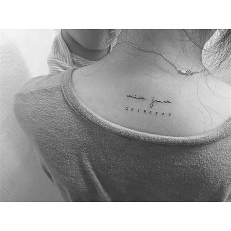 Name And Date Tattoo Located On The Upper Back