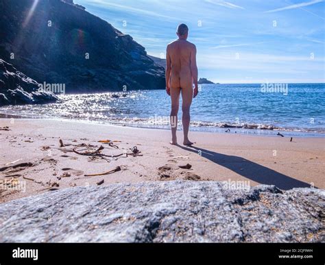 Back View Of A Fit Naked Man Looking Out To See From A Lonely Deserted
