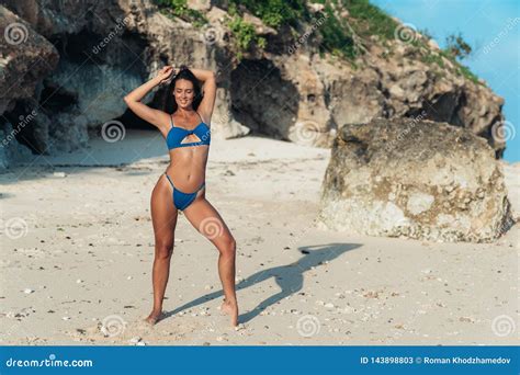 Brunette Girl In Blue Swimsuit Sunbathes On The White Sand Beach Stock Image Image Of Blue