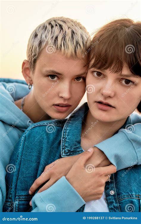 Portrait Of Two Attractive Young Women With Short Hair Looking At Camera Young Lesbian Couple