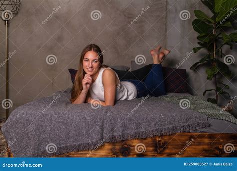 Smiling Woman Lying On Her Stomach In Bed Stock Image Image Of Jeans Girl 259883527