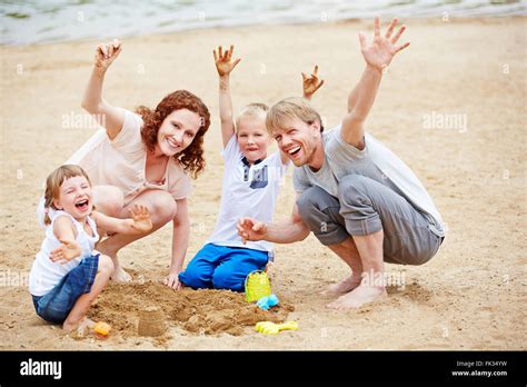 Familie Mit Zwei Kindern Im Sommer Am Strand Beim Bau Einer Sandburg