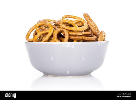Lot Of Whole Baked Mini Salted Pretzels In A Grey Ceramic Bowl Isolated