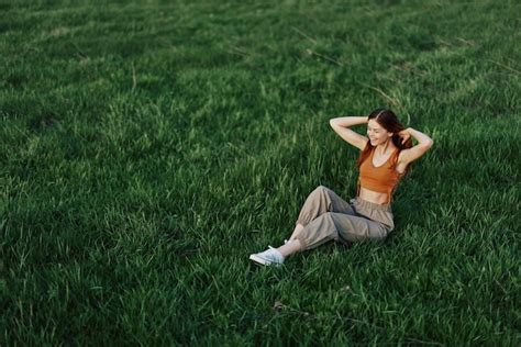 Premium Photo Young Woman Playing Games In The Park On The Green Grass Spreading Her Arms And