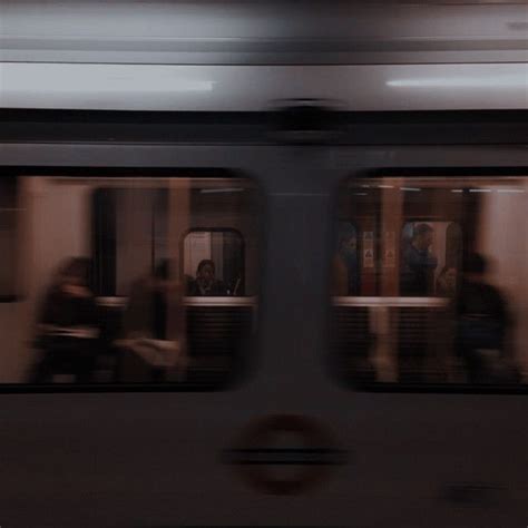 People Are Sitting On The Subway Train As It Passes By In Front Of Them