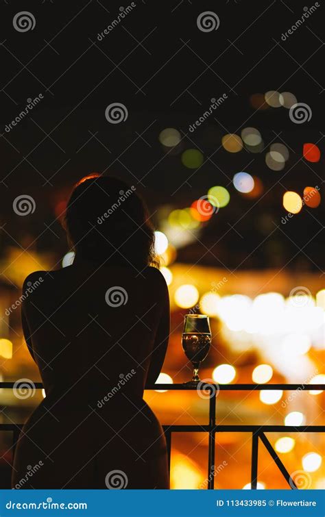 Silhouette Of Naked Woman On The Balcony With A Glass Of Wine On The