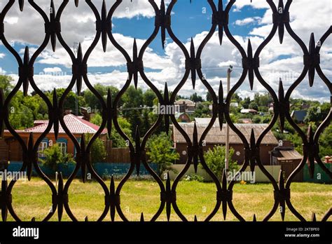 View Of A Small Provincial Town Through A Forged Iron Lattice Of The