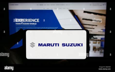 Person Holding Smartphone With Logo Of Indian Company Maruti Suzuki