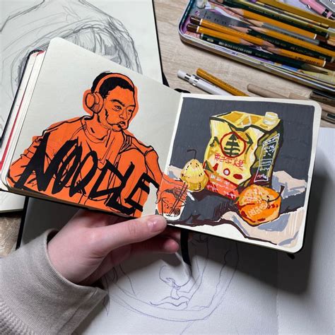 A Hand Holding An Open Notebook With Drawings On It And Another Drawing