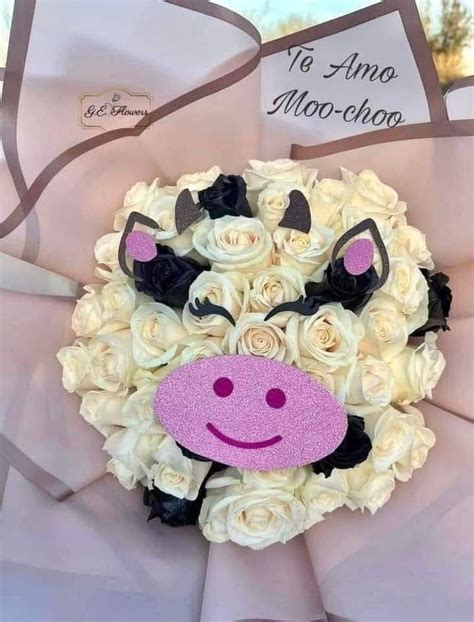 A Bouquet Of White Roses With A Pink Cow Face On The Front And An Ad