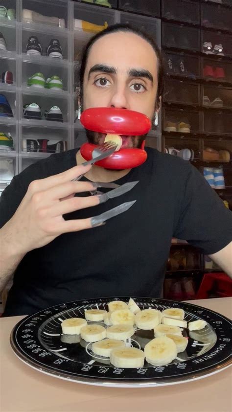 A Man Holding A Knife And Fork Over His Face With Bananas On The Plate