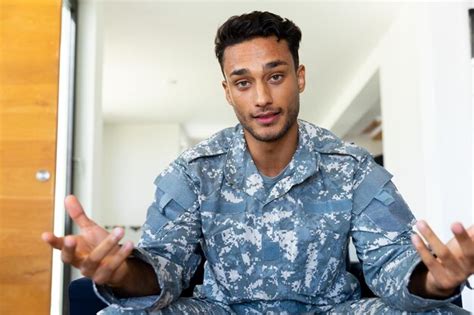 Premium Photo Happy Biracial Male Soldier Wearing Uniform Sitting In Armchair Making Video