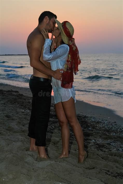 Pares Jovenes Felices Que Se Besan En La Playa En La Oscuridad Imagen
