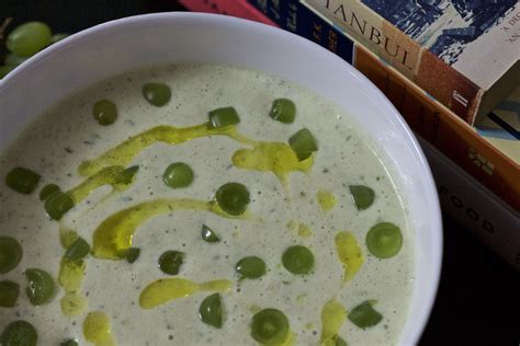 A White Bowl Filled With Soup Next To A Stack Of Books