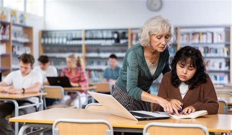 Profesora Madura De Una Colegiala Hace Un Chequeo De La Tarea Imagen De
