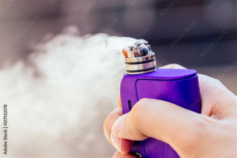 Purple Vape In A Man S Hand On A Modern Background Stock Photo Adobe