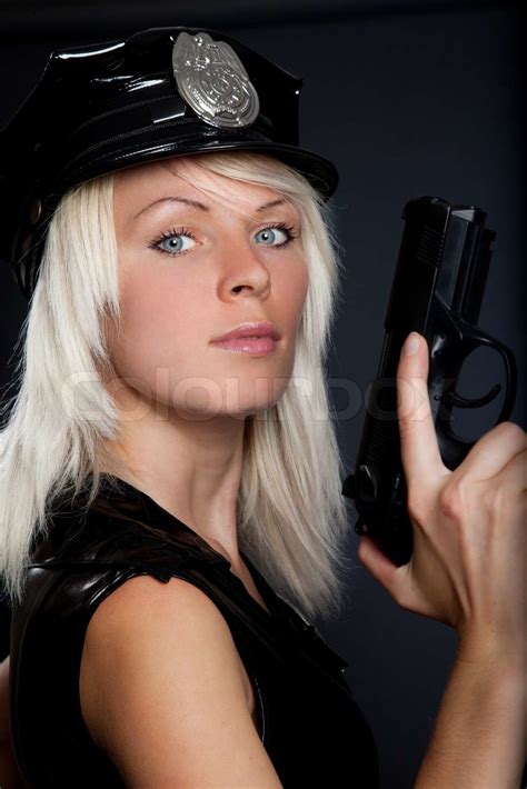 Smuk sexet politiet pige med pistol og håndjern isoleret på sort