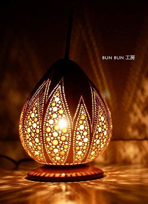 An Intricately Designed Lamp Is Lit Up On The Floor In Front Of A Dark