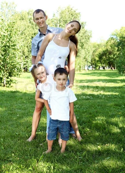 Junge glückliche Familie mit zwei Kindern im Sommer Park Stockfoto