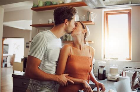 Premium Photo Romantic Couple Kissing Cooking And Showing Affection In Love While Bonding