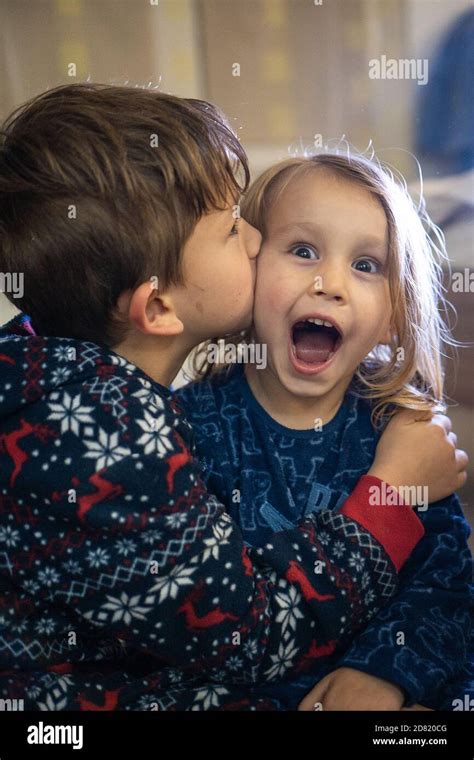 Deux frères et sœurs en pyjama avec livre soeur baiser frère drôle