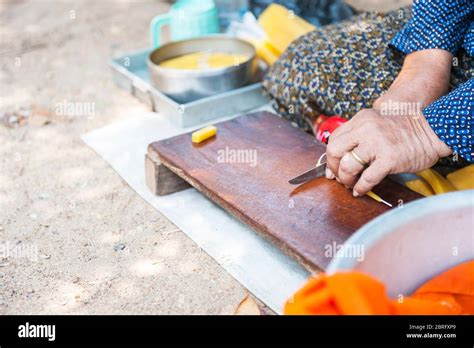 A Close Up Of A Womans Hands Making Candles For Offerings In Temples