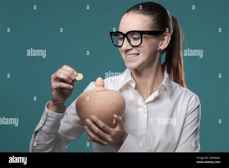 Happy Business Woman Putting Her Savings In A Safe Money Box Investments And Finance Concept