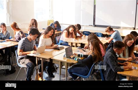 Wide Angle View Of High School Students Sitting At Desks In Classroom