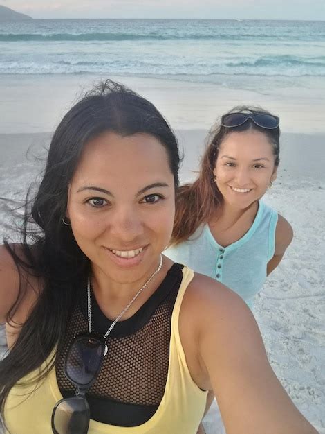 Premium Photo Portrait Of Female Friends Smiling While Standing At Beach