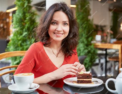 Premium Photo Portrait Of Woman Sitting In Cafe Having Coffee And Cake
