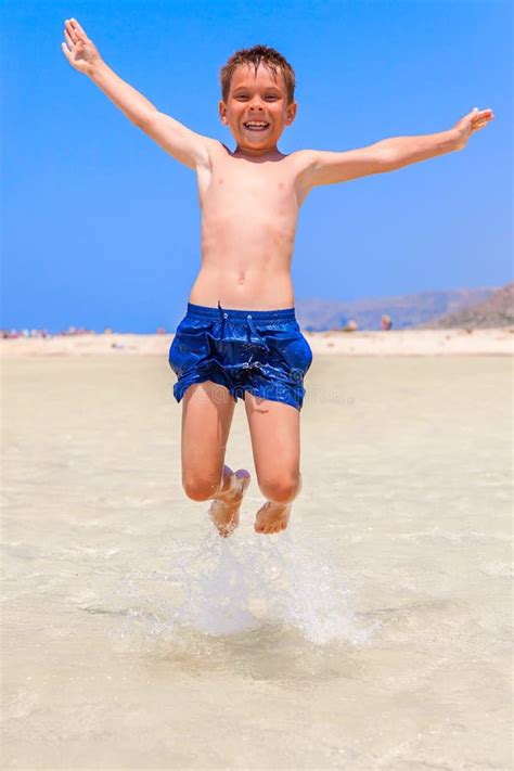 Le Gar On Sautant Sur La Plage Image Stock Image Du Ciel Vacances