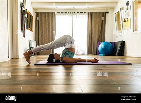 Side View Of A Woman Practicing Yoga Doing Plow Pose Halasana Pose