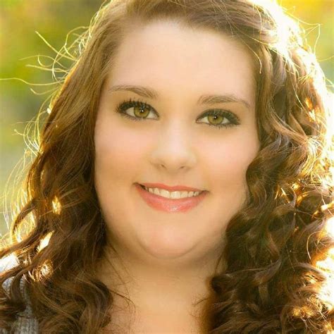 A Close Up Of A Person With Long Hair And Green Eyeshade Smiling At The