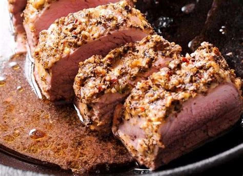 Sliced Meat Sitting On Top Of A Pan Covered In Sauce And Seasoning